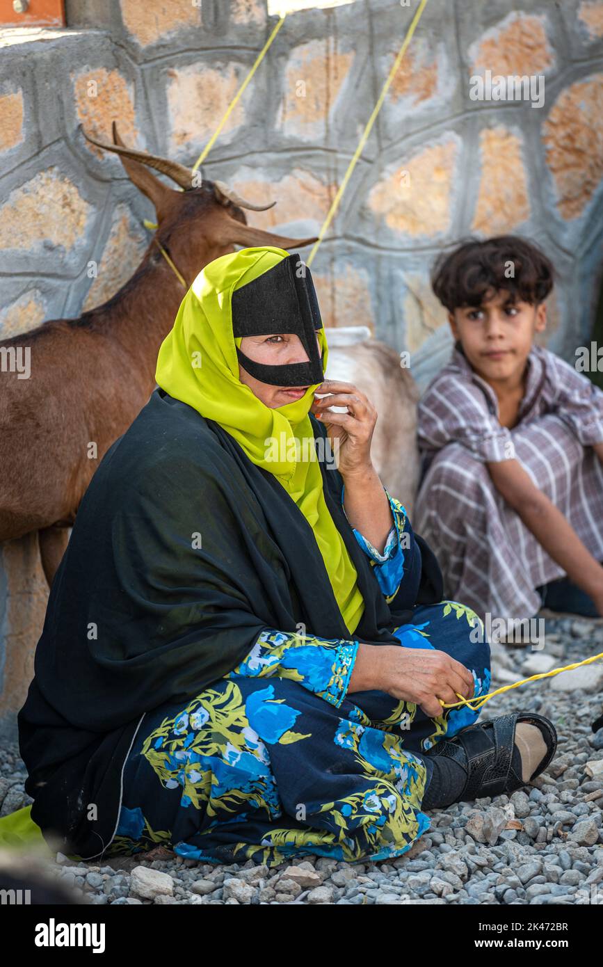 Woman with black "battoulah" (face mask) at friday morning cattle ...