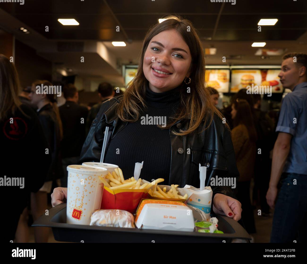 A customer seen smiling while carrying her tray of food. Fast food ...