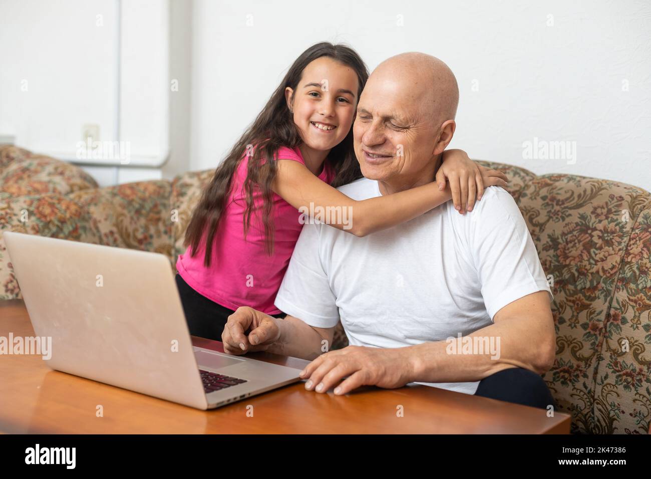Grandfather and granddaughter spend time together use laptop, browse ...