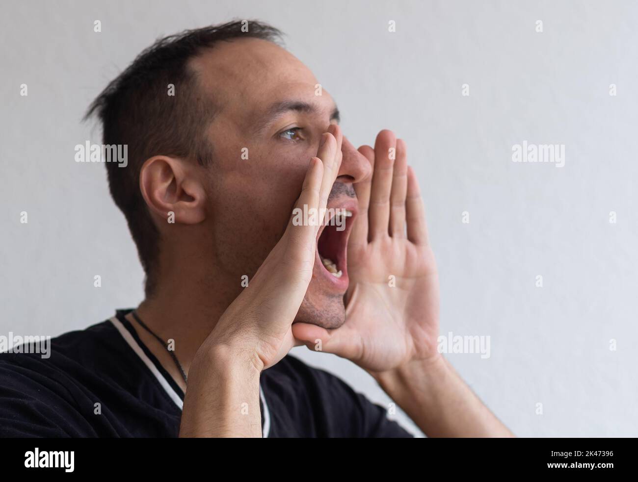 Handsome happy man wearing T-shirt, guy speaking loudly, isolated on white background Stock ...