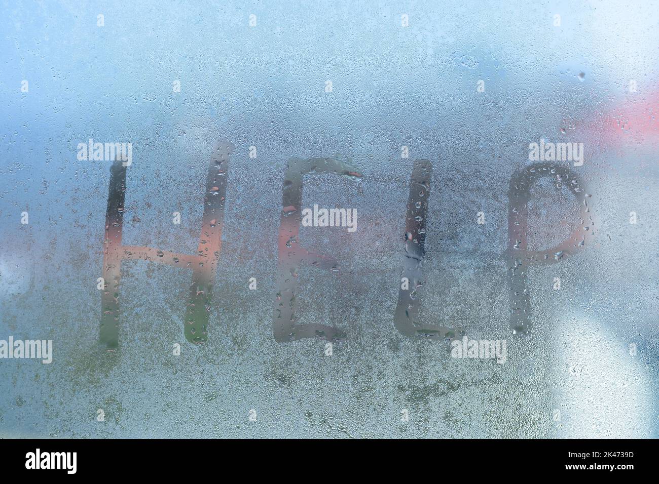 words help handwritten on night wet window glass with green and blue ...