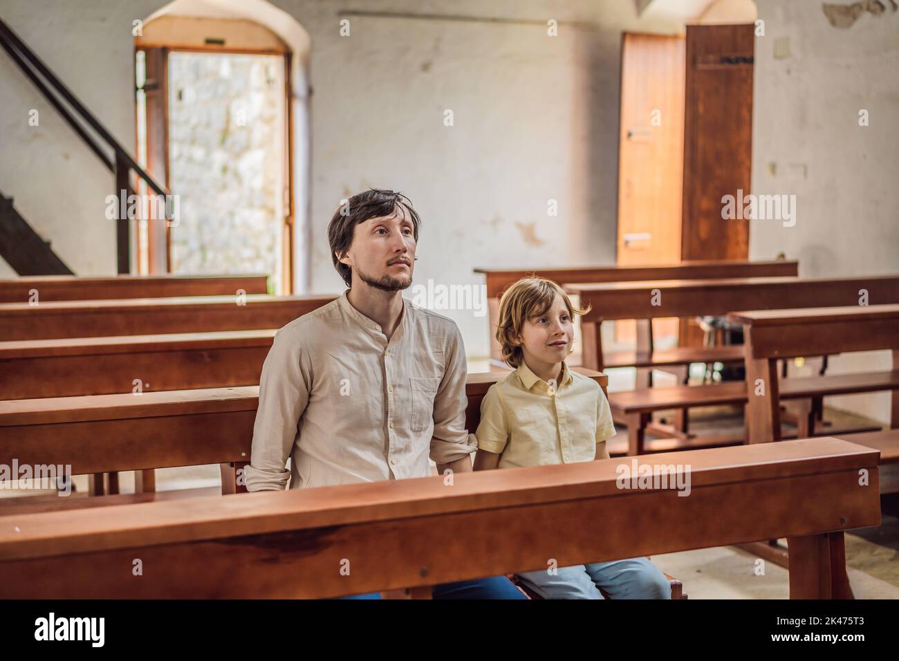 Christian dad tells his son Bible stories about Jesus sitting in kirk ...