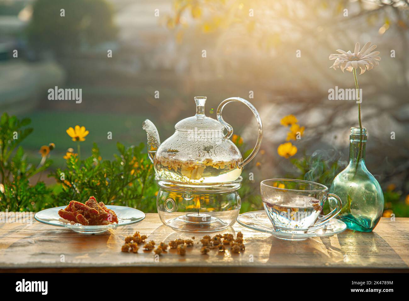 Chrysanthemum tea with hot steam and sweet potato jam on wooden table ...