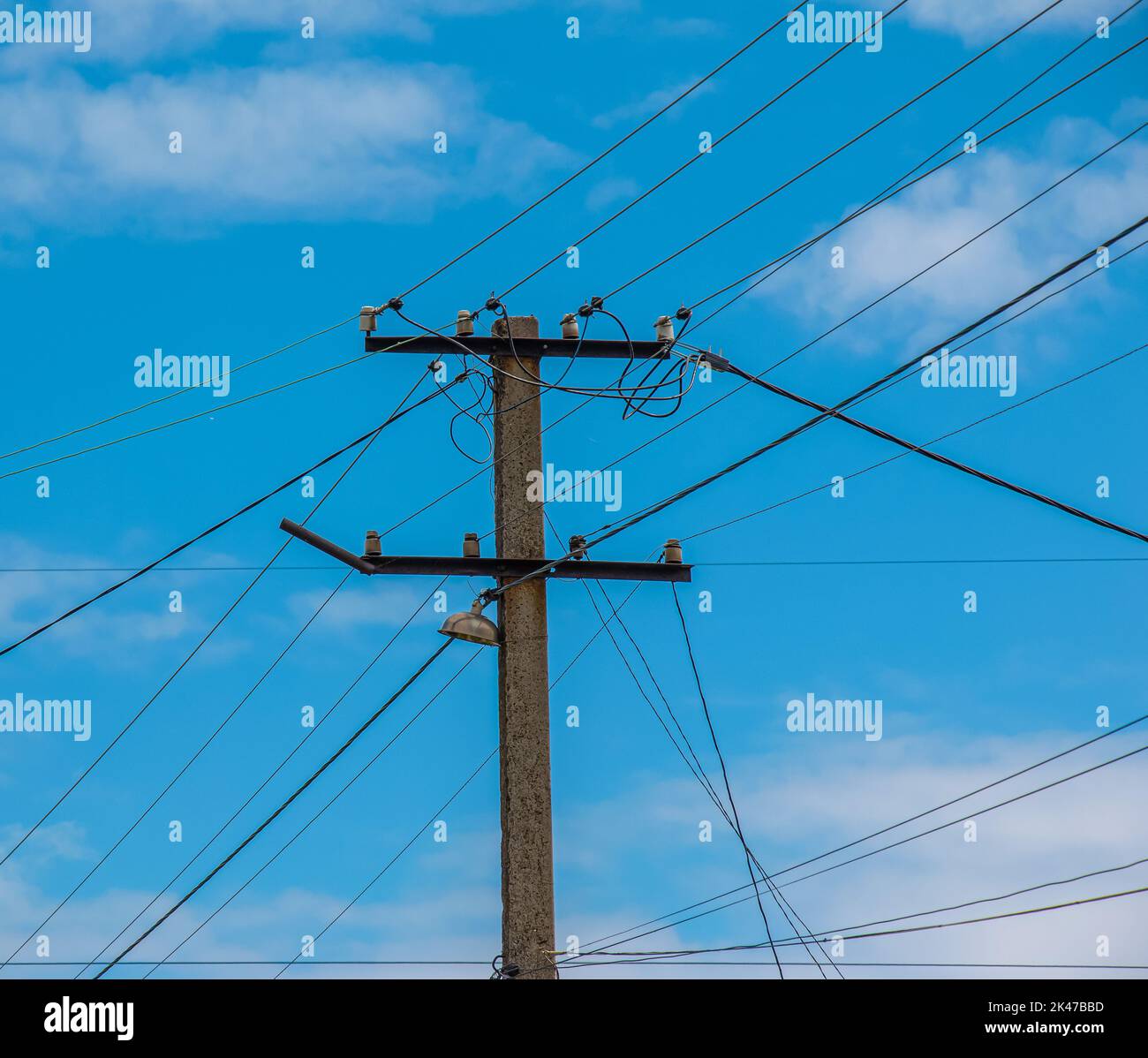Electric pole power lines outgoing electric wires againts on cloud blue ...