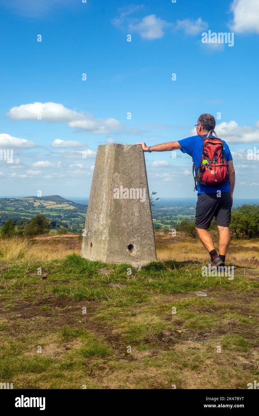 Man standing by the trig point on Gun hill while walking on Gun Moor in ...