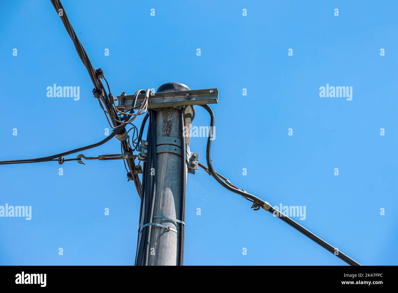 Electric pole power lines outgoing electric wires againts on cloud blue ...