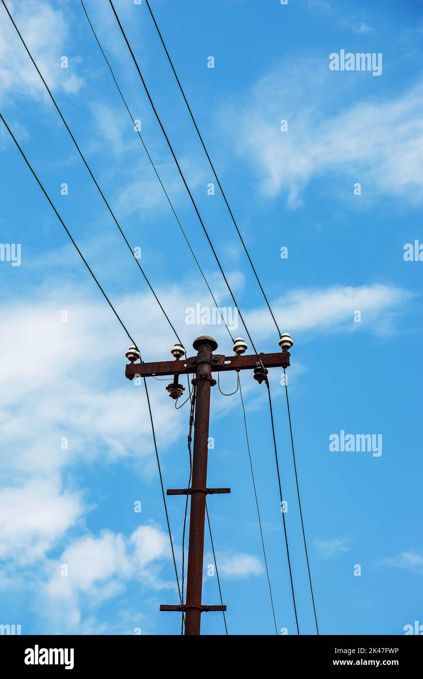 Electric pole power lines outgoing electric wires againts on cloud blue ...