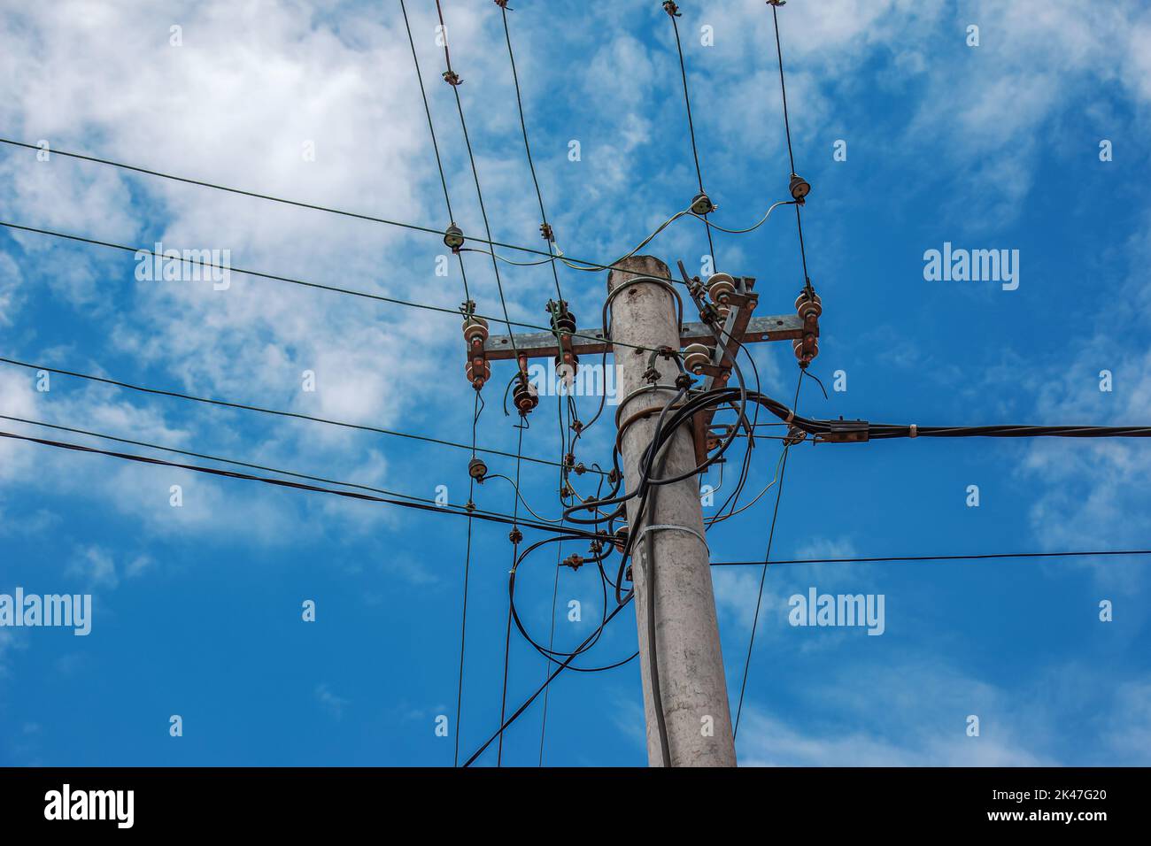 Electric pole power lines outgoing electric wires againts on cloud blue ...