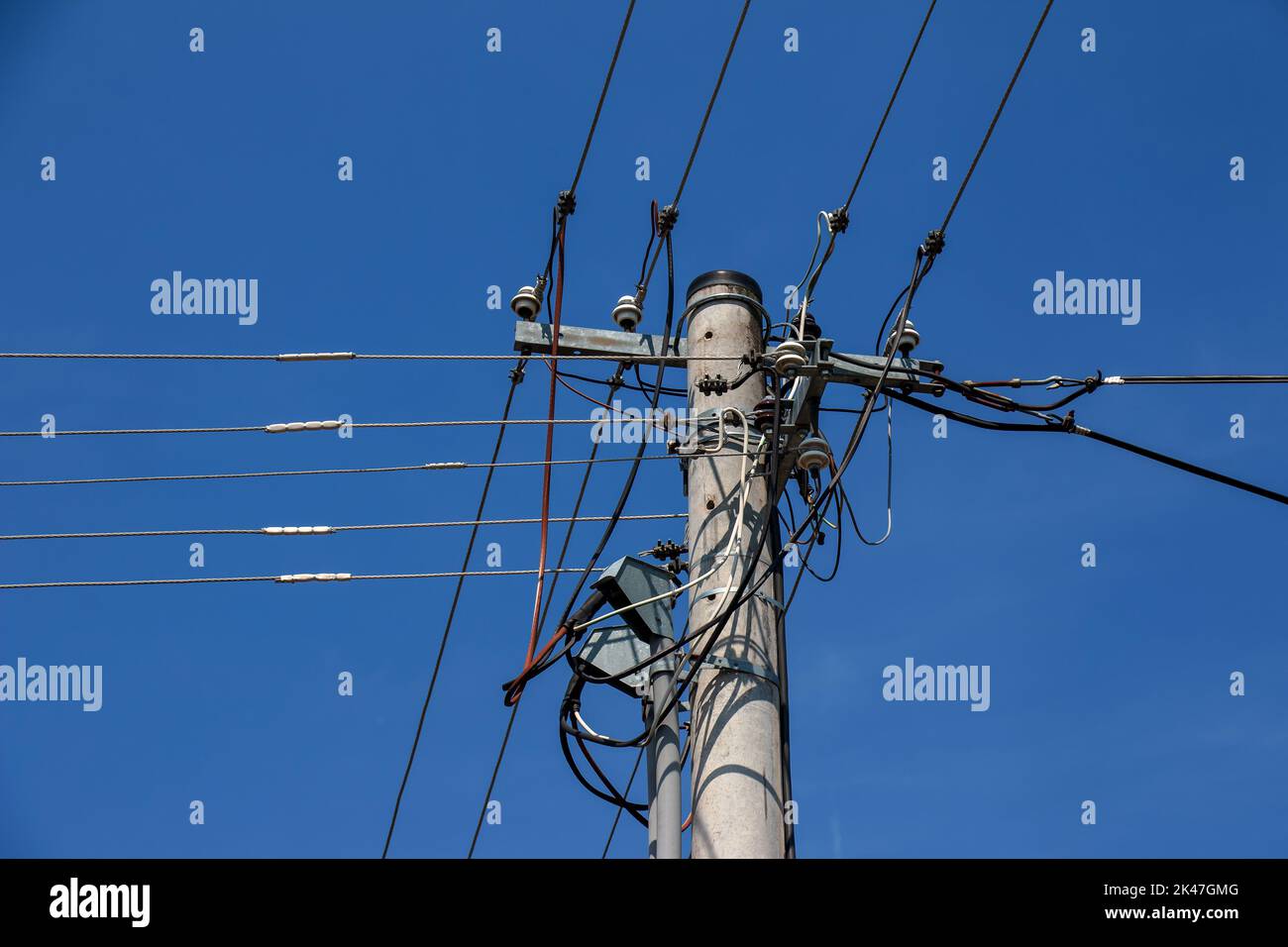 Electric pole power lines outgoing electric wires againts on cloud blue ...