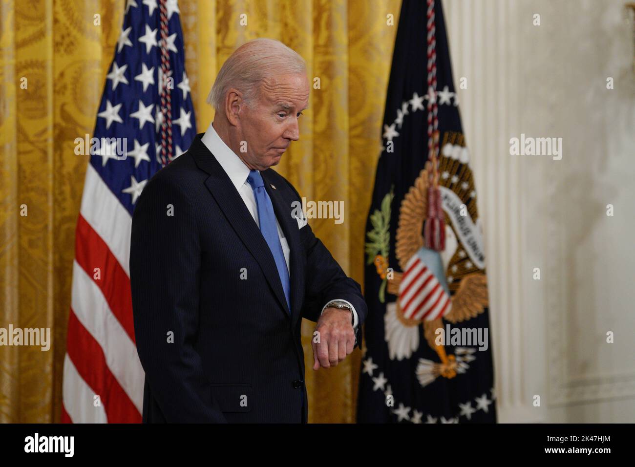 United States President Joe Biden looks at his watch as he attends a ...