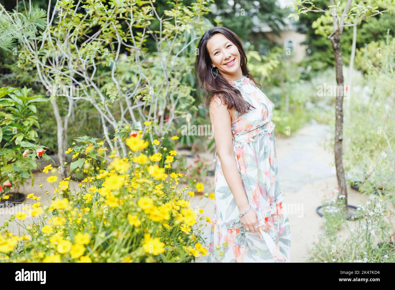 Beautiful happy mixed race Japanese woman in romantic floral maxi dress ...