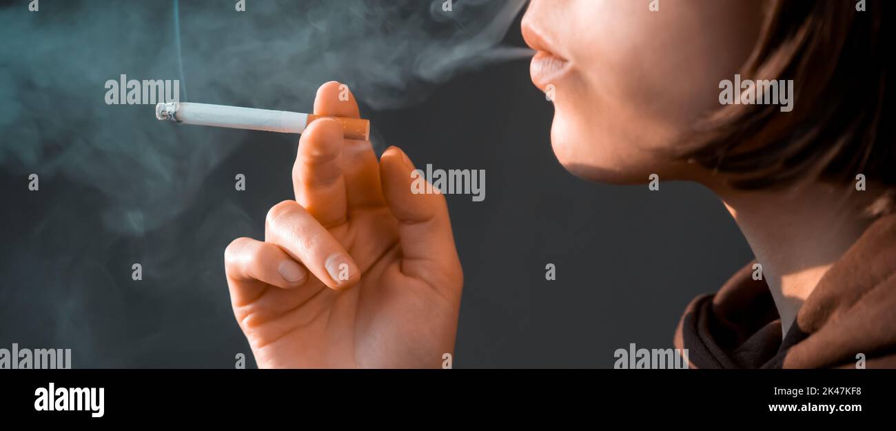 Woman is smoking, holding a cigarette in her hand Stock Photo - Alamy