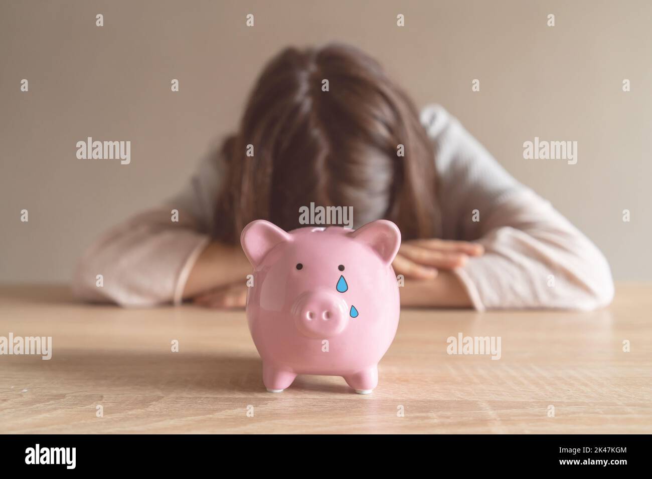 Sad girl with a crying piggy bank Stock Photo - Alamy