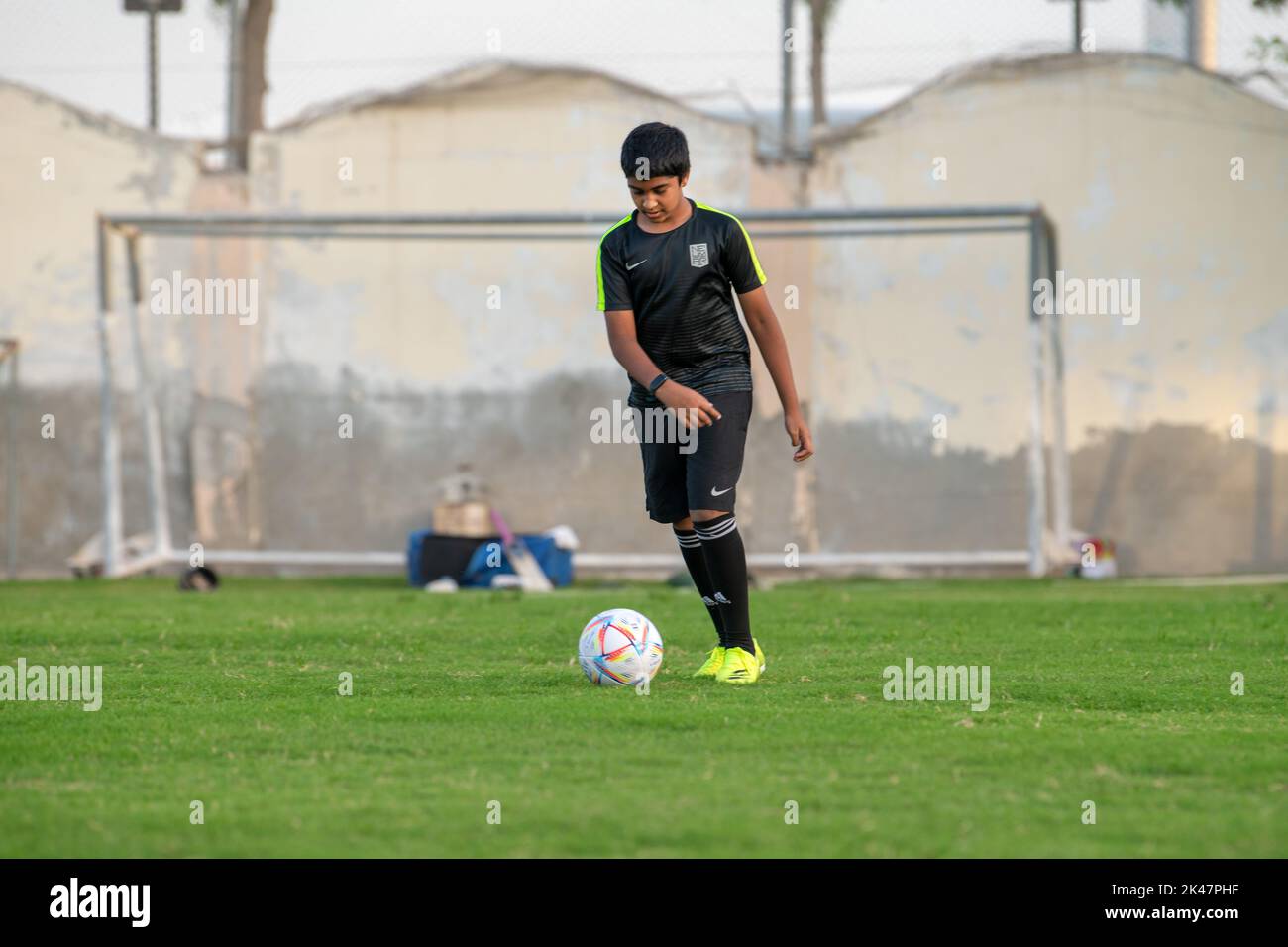 Young Kid Footballer playing in street ground with FIFA Qatar Official ...
