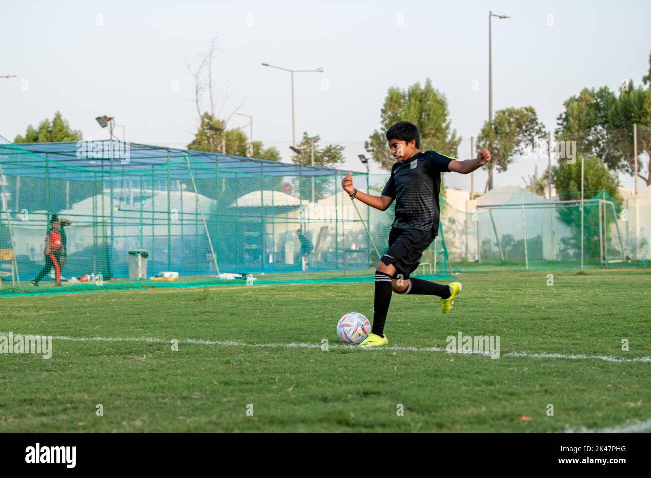 Young Kid Footballer playing in street ground with FIFA Qatar Official ...
