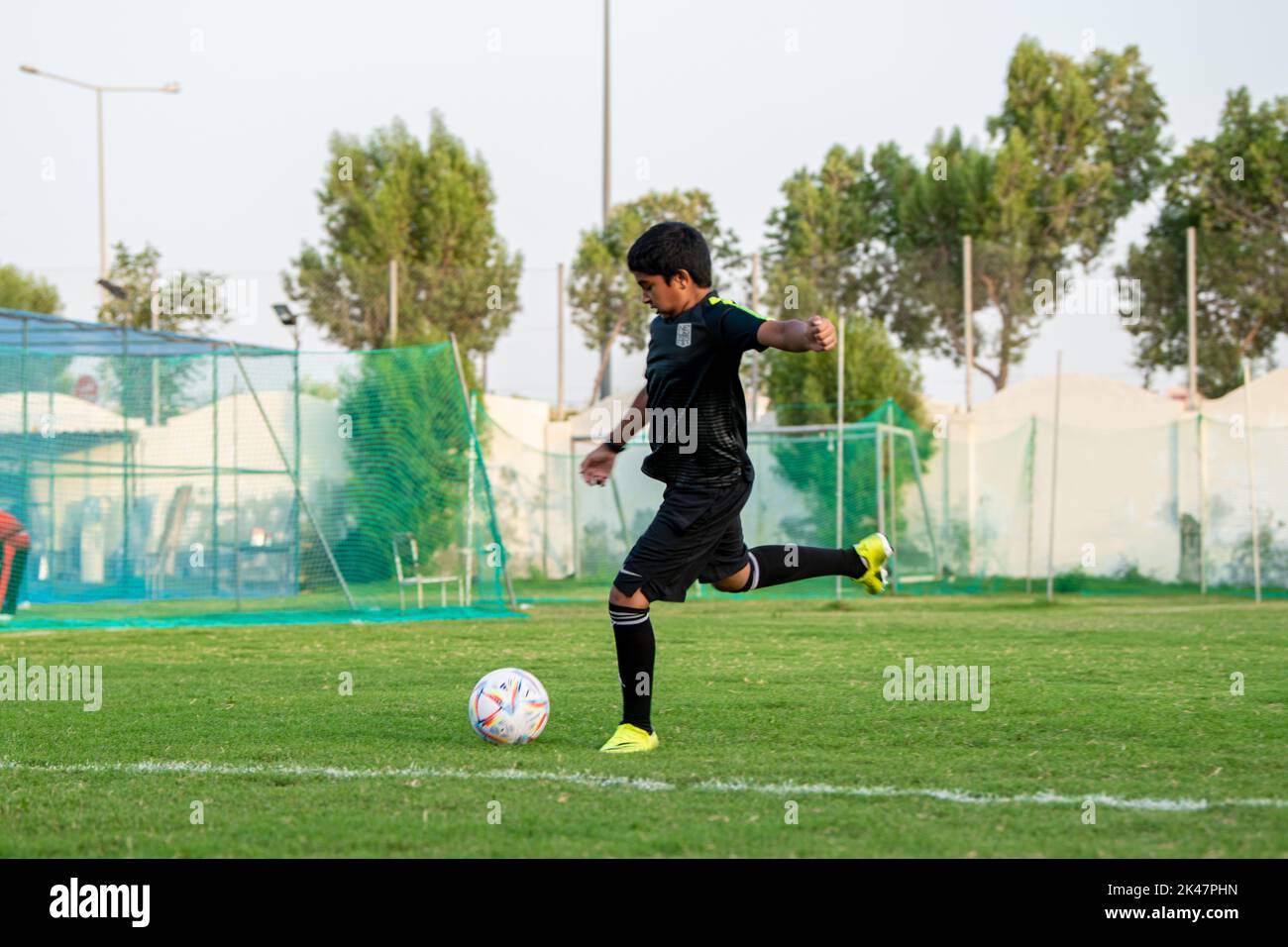 Young Kid Footballer playing in street ground with FIFA Qatar Official ...