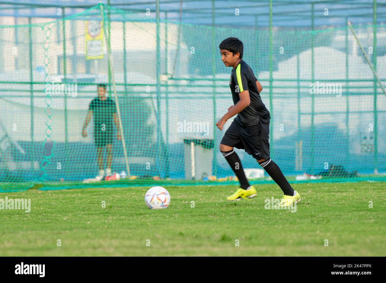 Young Kid Footballer playing in street ground with FIFA Qatar Official ...