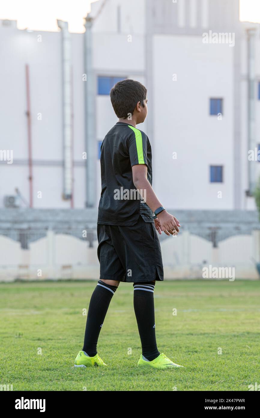 Young Kid Footballer playing in street ground with FIFA Qatar Official ...