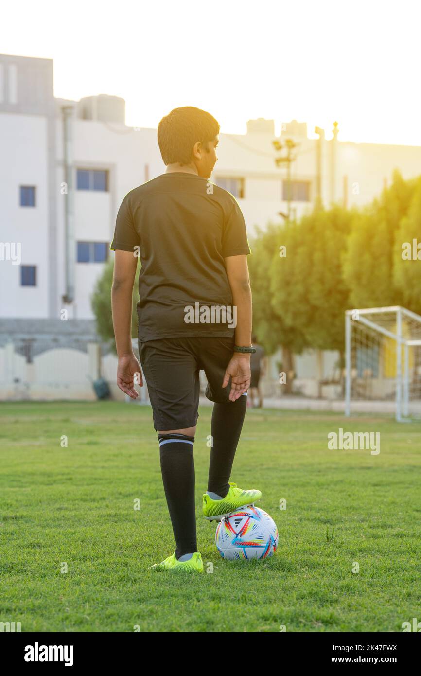 Young Kid Footballer playing in street ground with FIFA Qatar Official ...