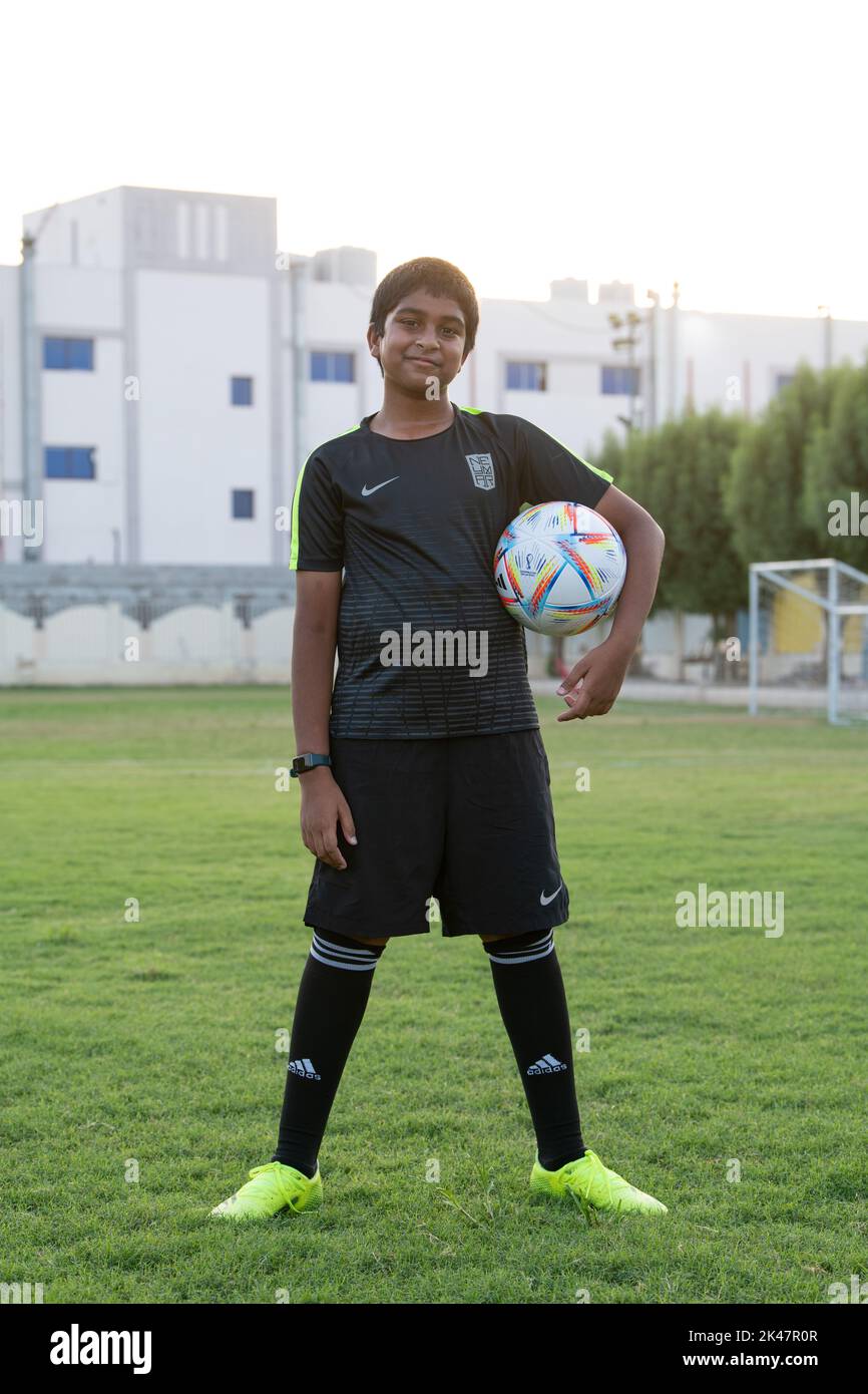 Young Kid Footballer playing in street ground with FIFA Qatar Official ...