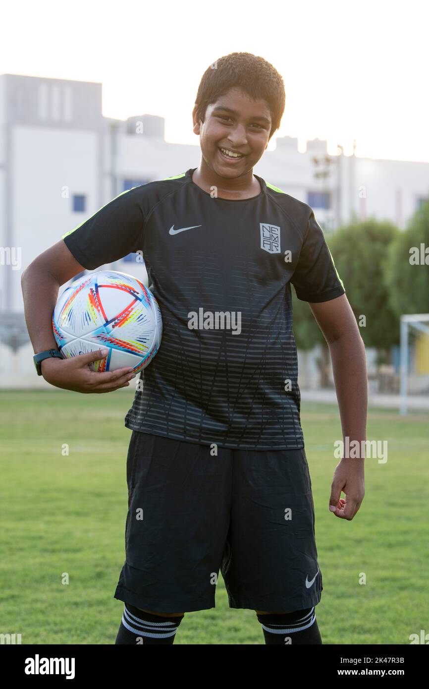 Young Kid Footballer playing in street ground with FIFA Qatar Official ...