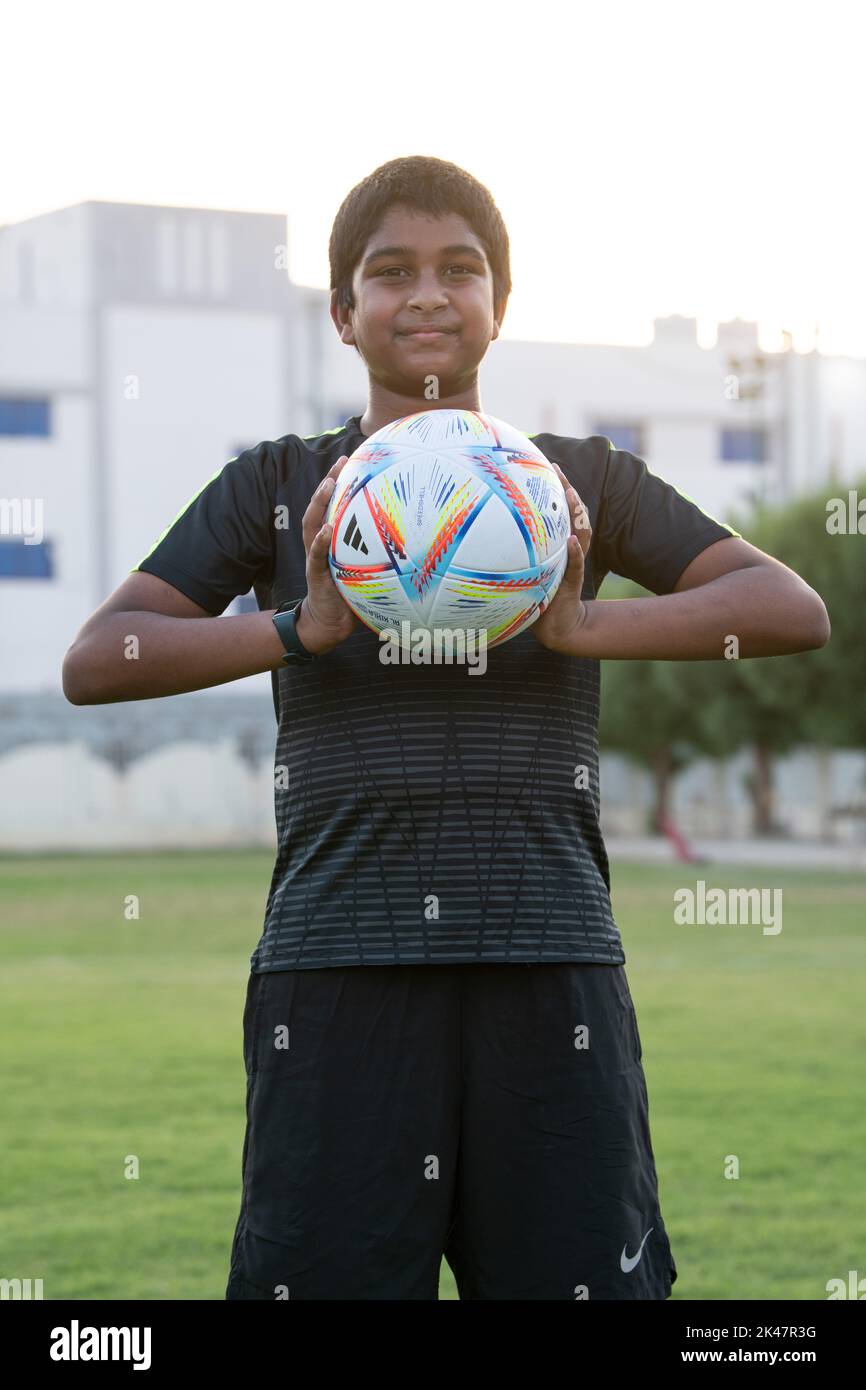 Young Kid Footballer playing in street ground with FIFA Qatar Official ...