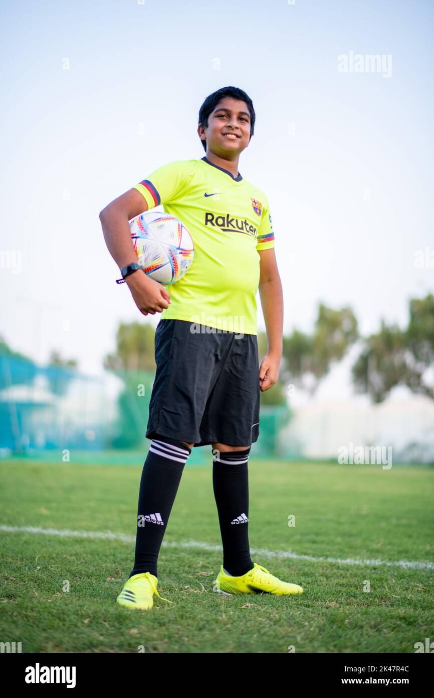 Young Kid Footballer playing in street ground with FIFA Qatar Official ...