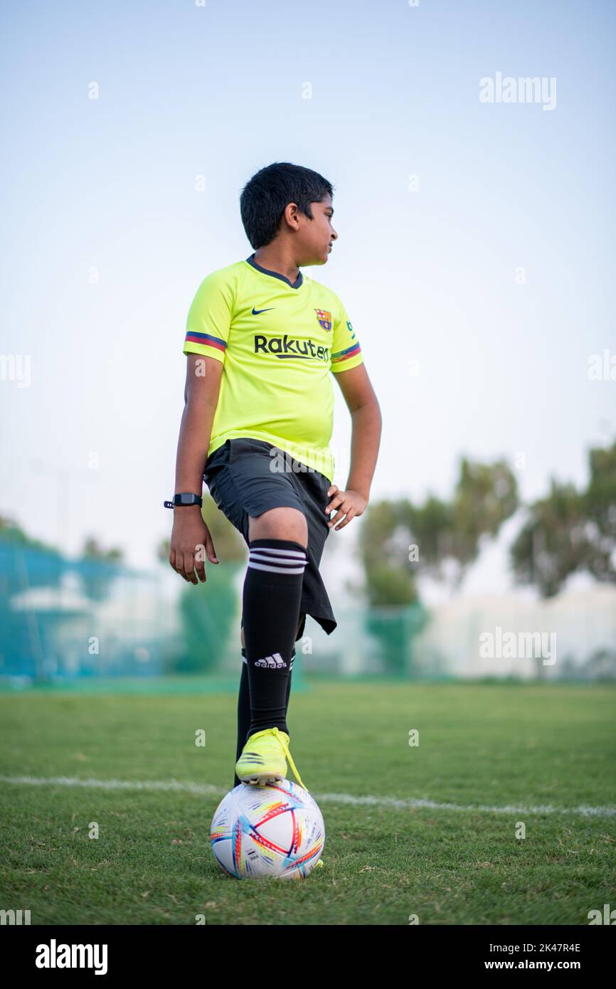 Young Kid Footballer playing in street ground with FIFA Qatar Official ...