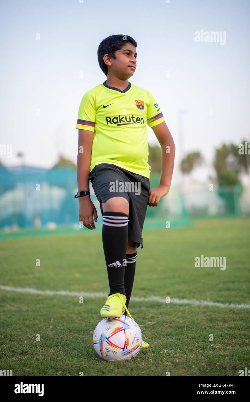 Young Kid Footballer playing in street ground with FIFA Qatar Official ...
