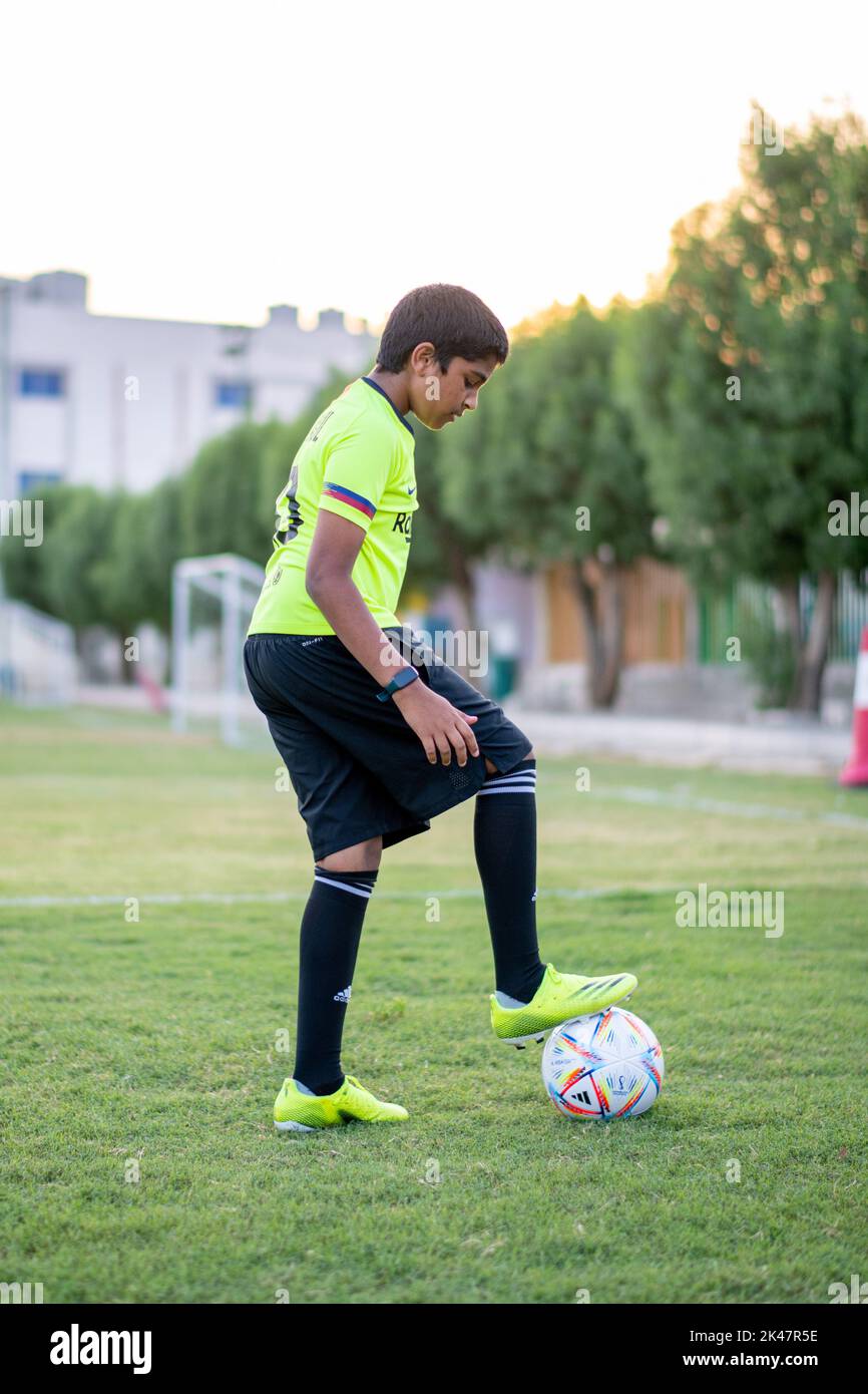 Young Kid Footballer playing in street ground with FIFA Qatar Official ...