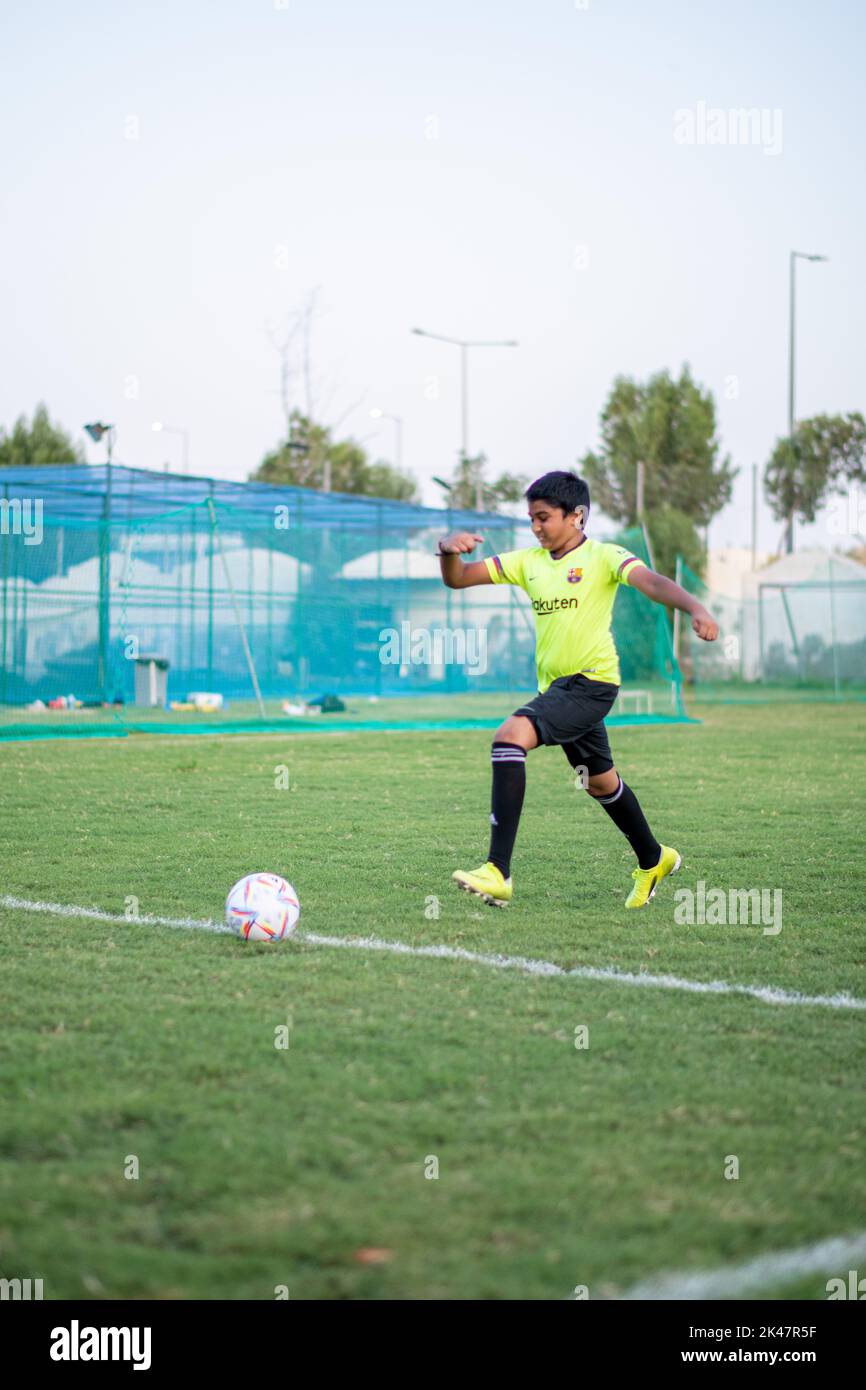 Young Kid Footballer playing in street ground with FIFA Qatar Official ...