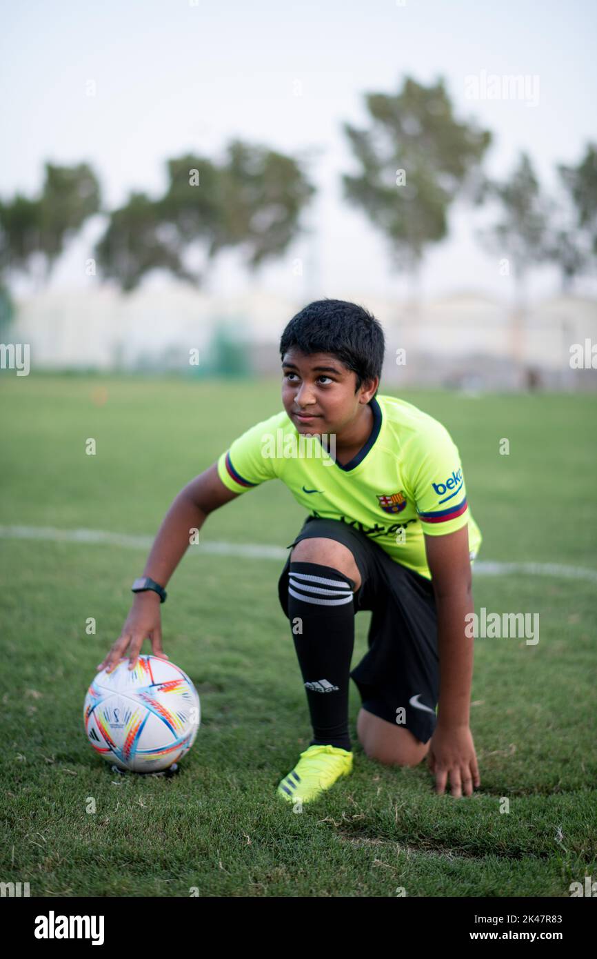 Young Kid Footballer playing in street ground with FIFA Qatar Official ...