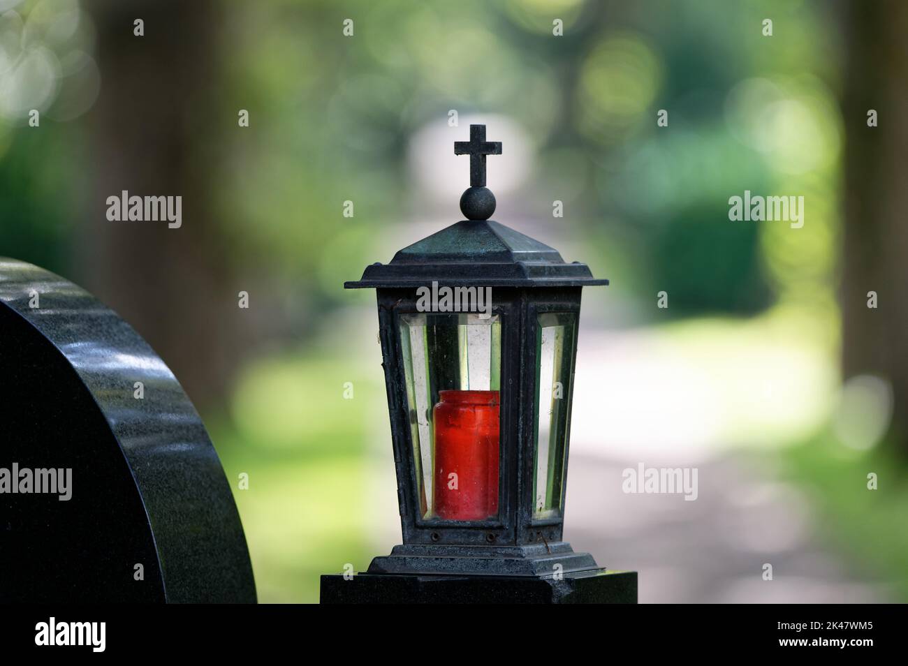 old fashioned grave lantern with cross on a tombstone in front of blurred background Stock Photo ...