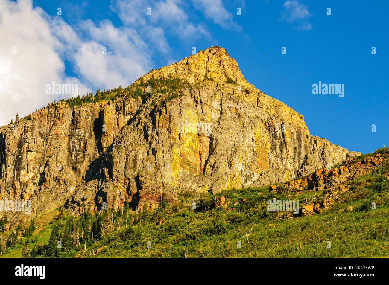 A tall cliff face stained with sulphur in the Waterton area of Alberta ...