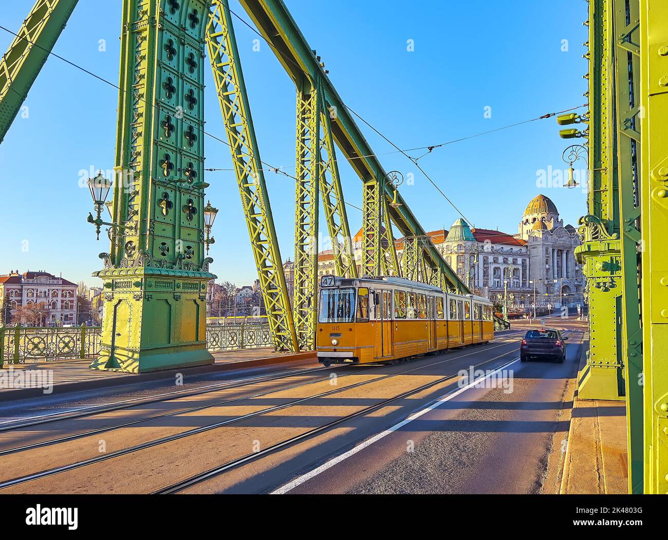 The Liberty Bridge on sunrise with a riding yellow tram against ...