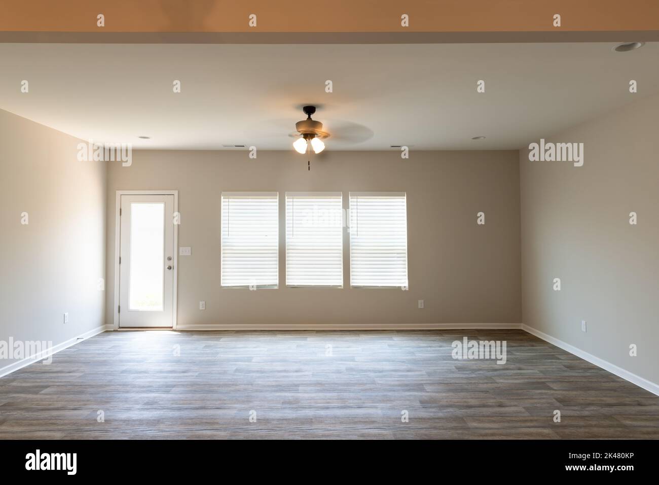 Empty dinning room in a townhouse with ceiling fan, a door, and window ...