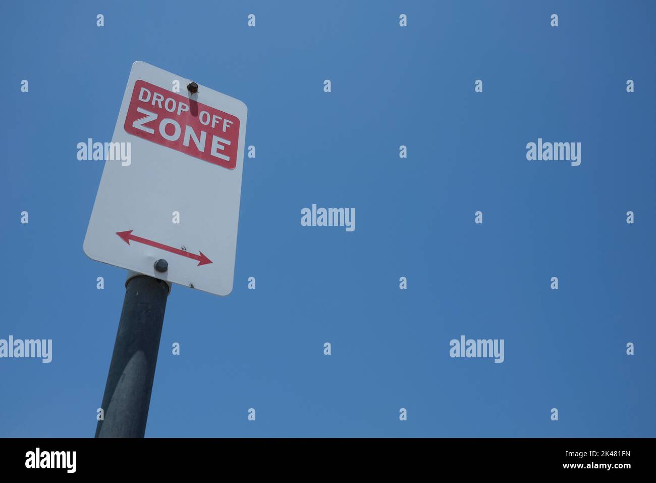 a drop off zone sign against a clear blue sky Stock Photo - Alamy