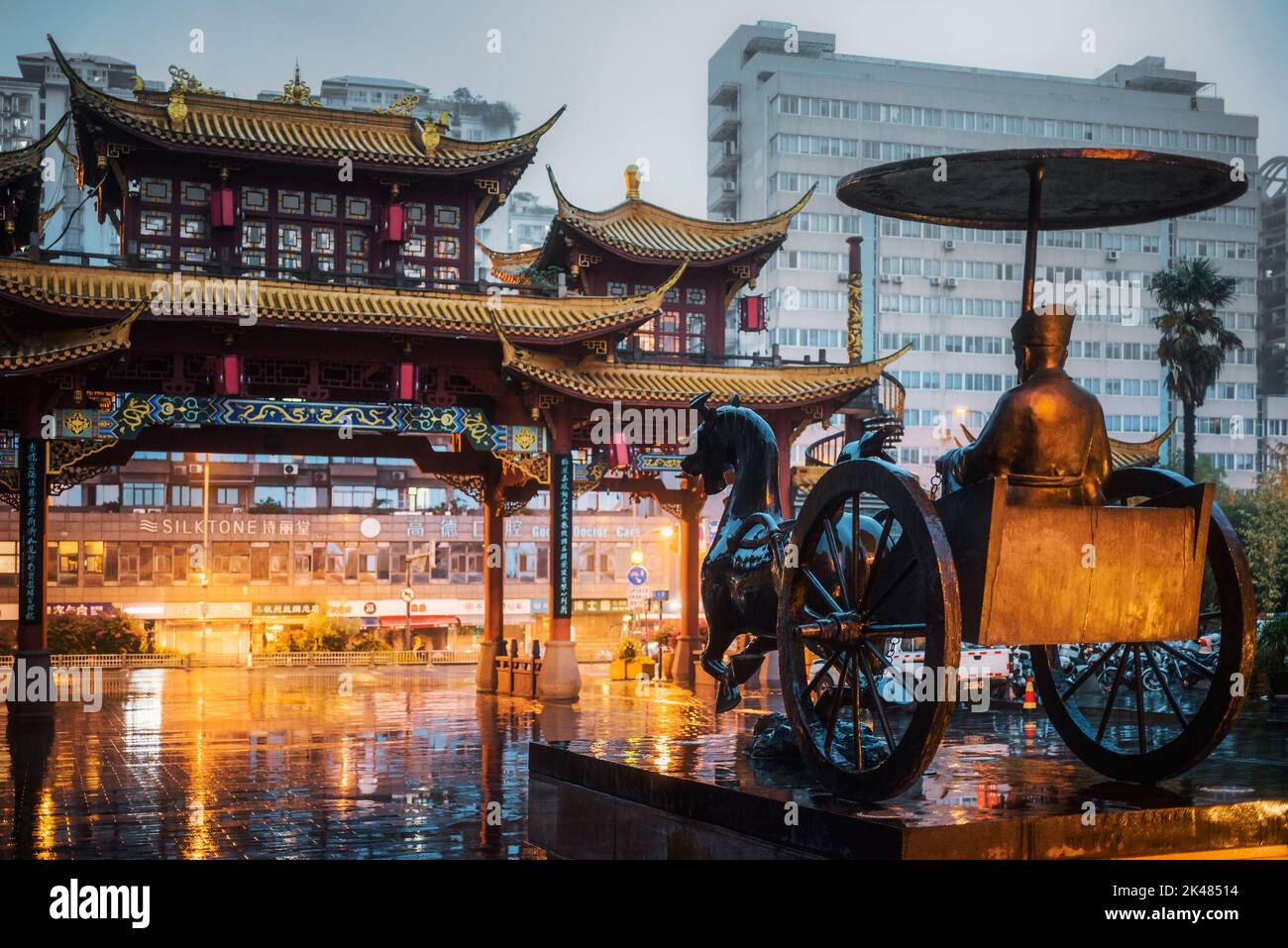 QinTailLu traditional Chinese gate and statue under the rain at dusk in ...