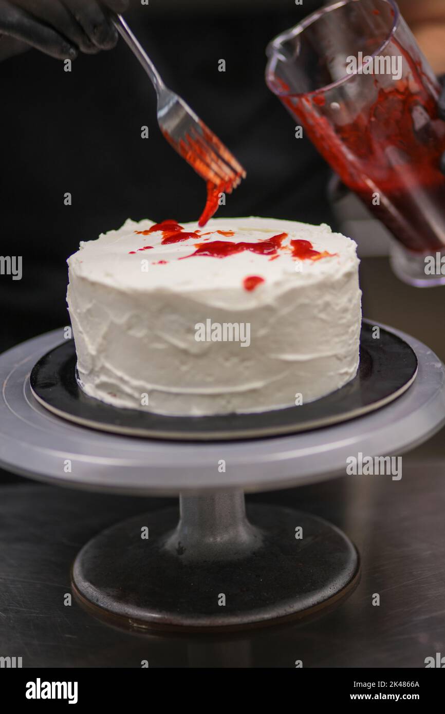 Bleeding monster cake with knife on cake stand Stock Photo - Alamy