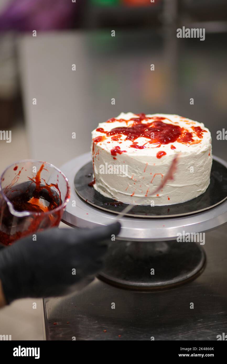 Bleeding monster cake with knife on cake stand Stock Photo - Alamy