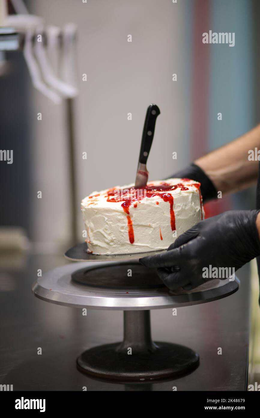 Bleeding monster cake with knife on cake stand Stock Photo - Alamy