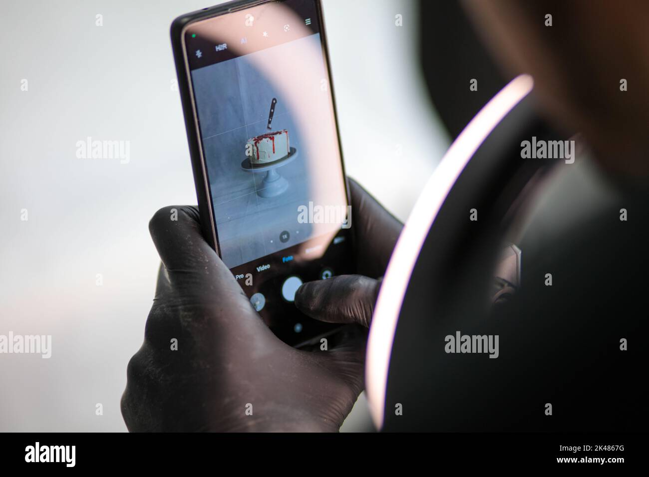Photographing a bleeding monster cake with knife on cake stand Stock ...