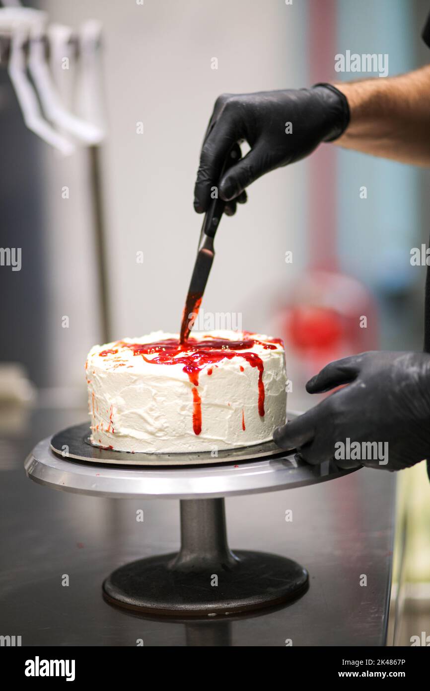 Bleeding monster cake with knife on cake stand Stock Photo - Alamy