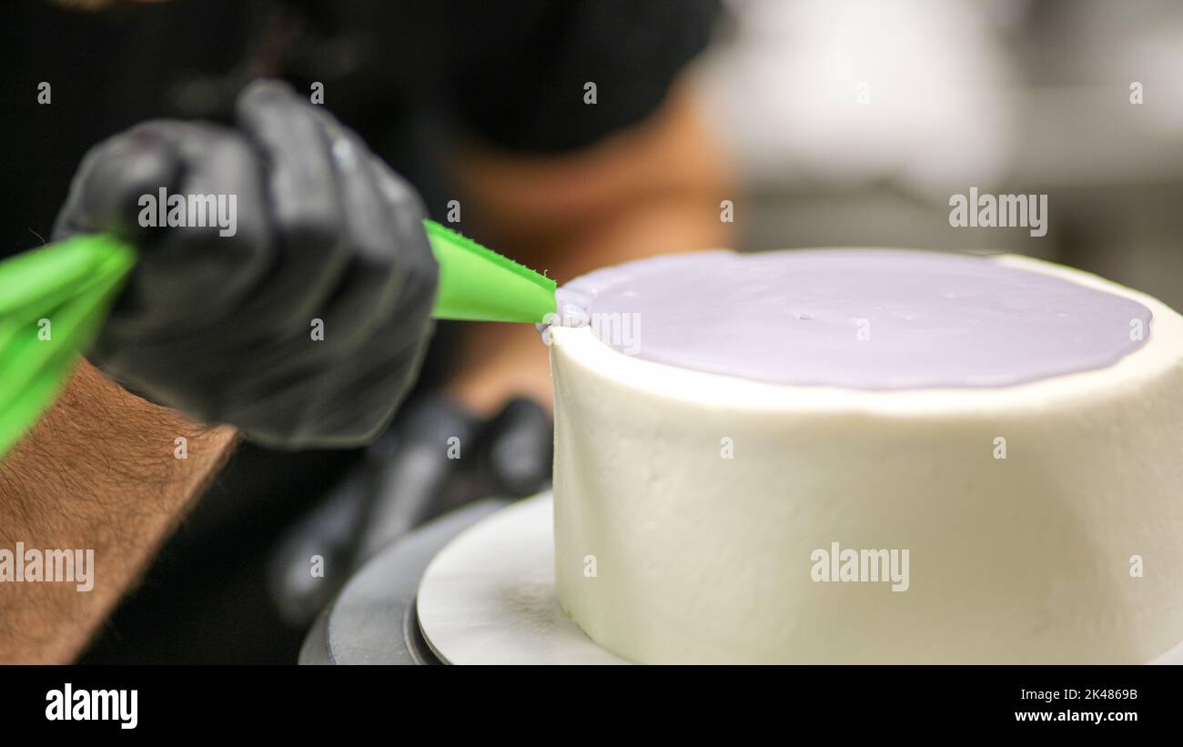chef using using bag decorating a frosted icing cake Stock Photo - Alamy