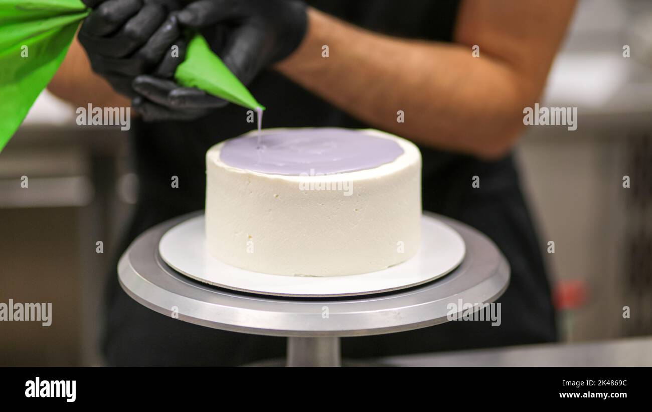 chef using using bag decorating a frosted icing cake Stock Photo - Alamy