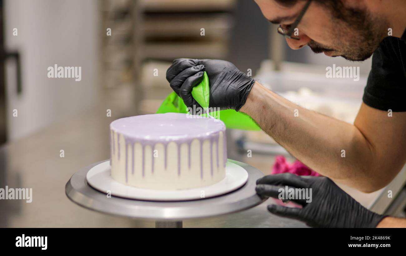 chef using using bag decorating a frosted icing cake Stock Photo - Alamy