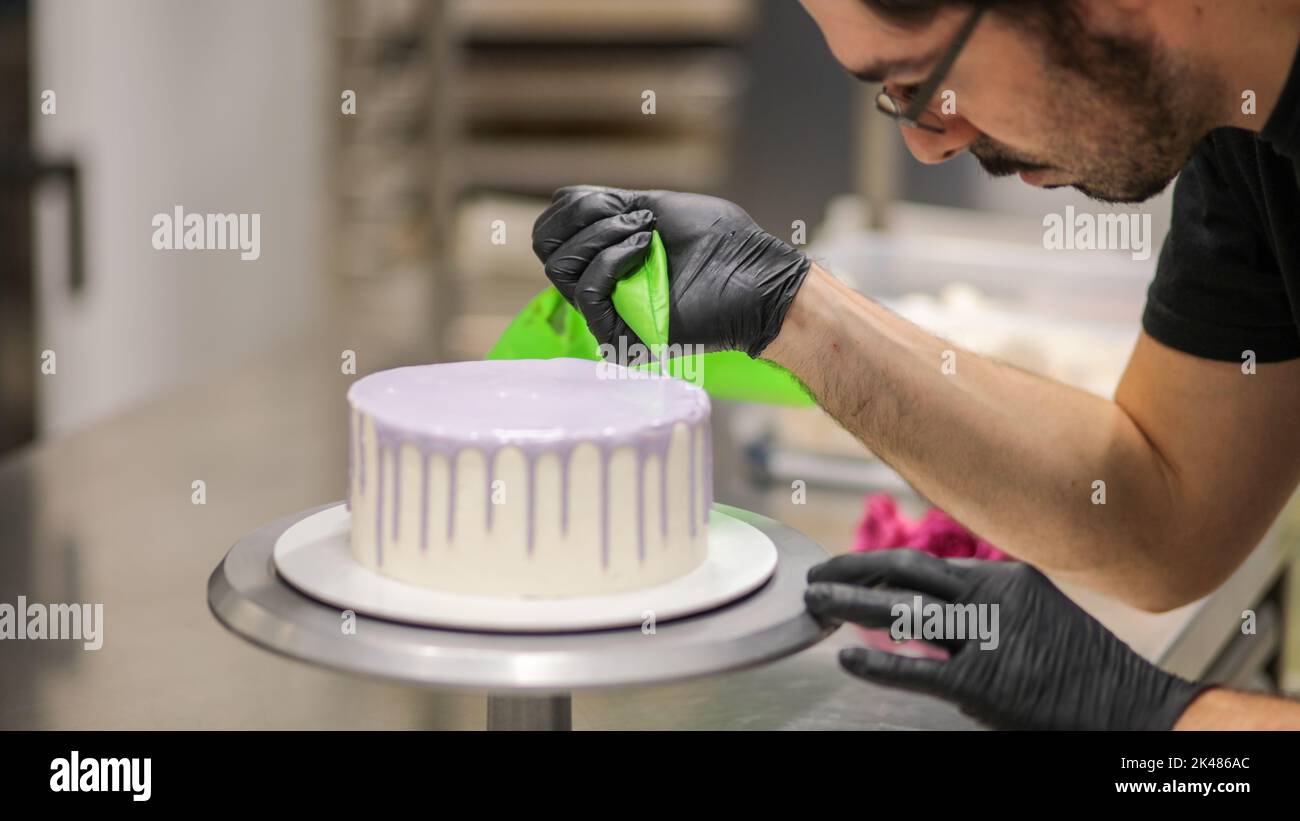 chef using using bag decorating a frosted icing cake Stock Photo - Alamy