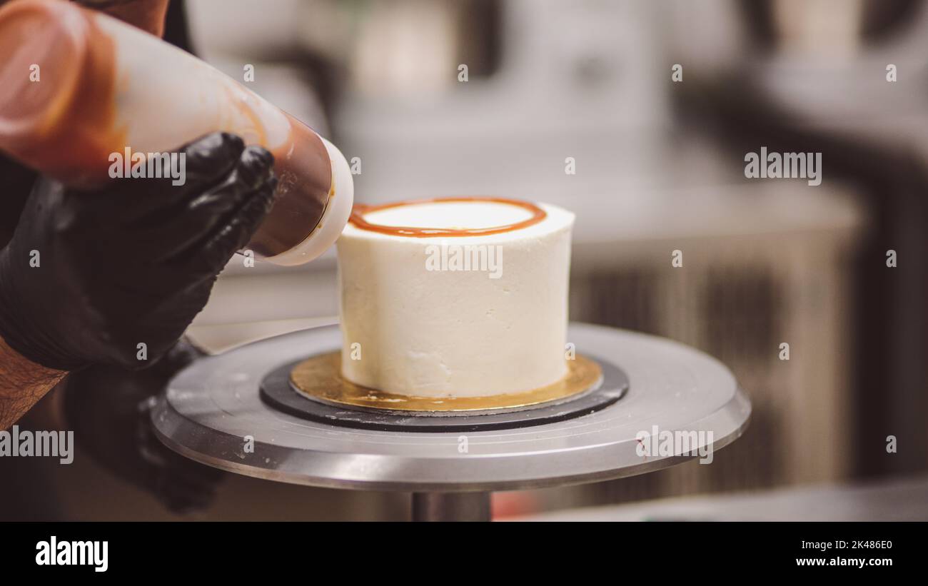 chef decorating the top of a frosted buttercream cake Stock Photo - Alamy