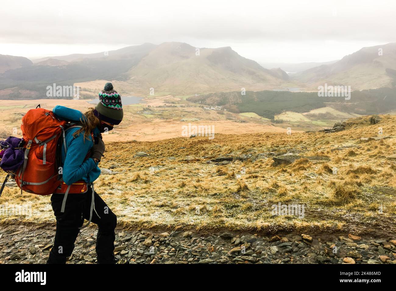 Female hikers hike up mountain in cold misty morning weather. Hiking ...