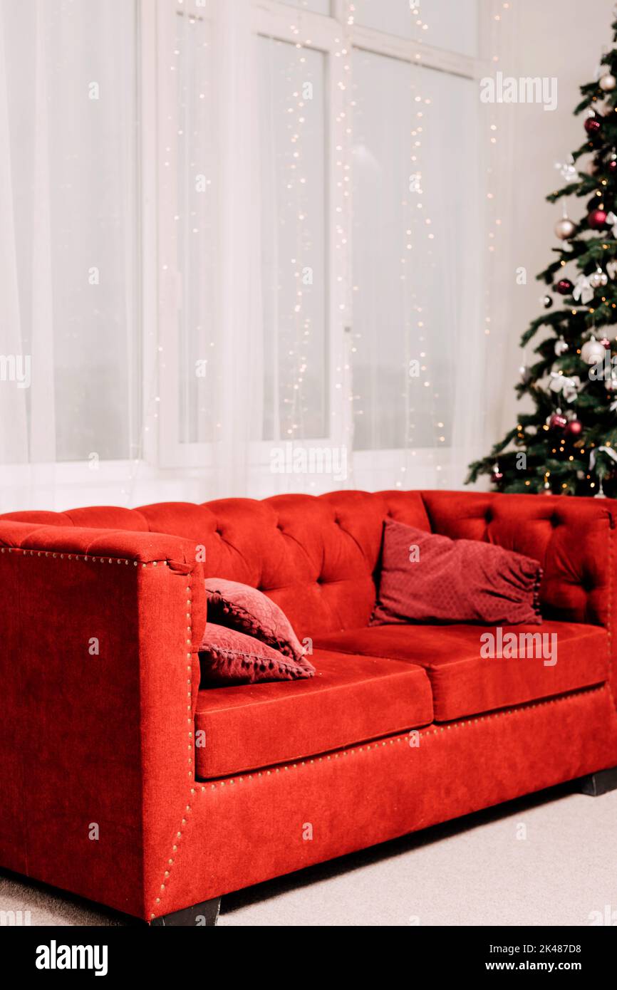 Red modern sofa next to the Christmas tree New Year Interior Stock ...